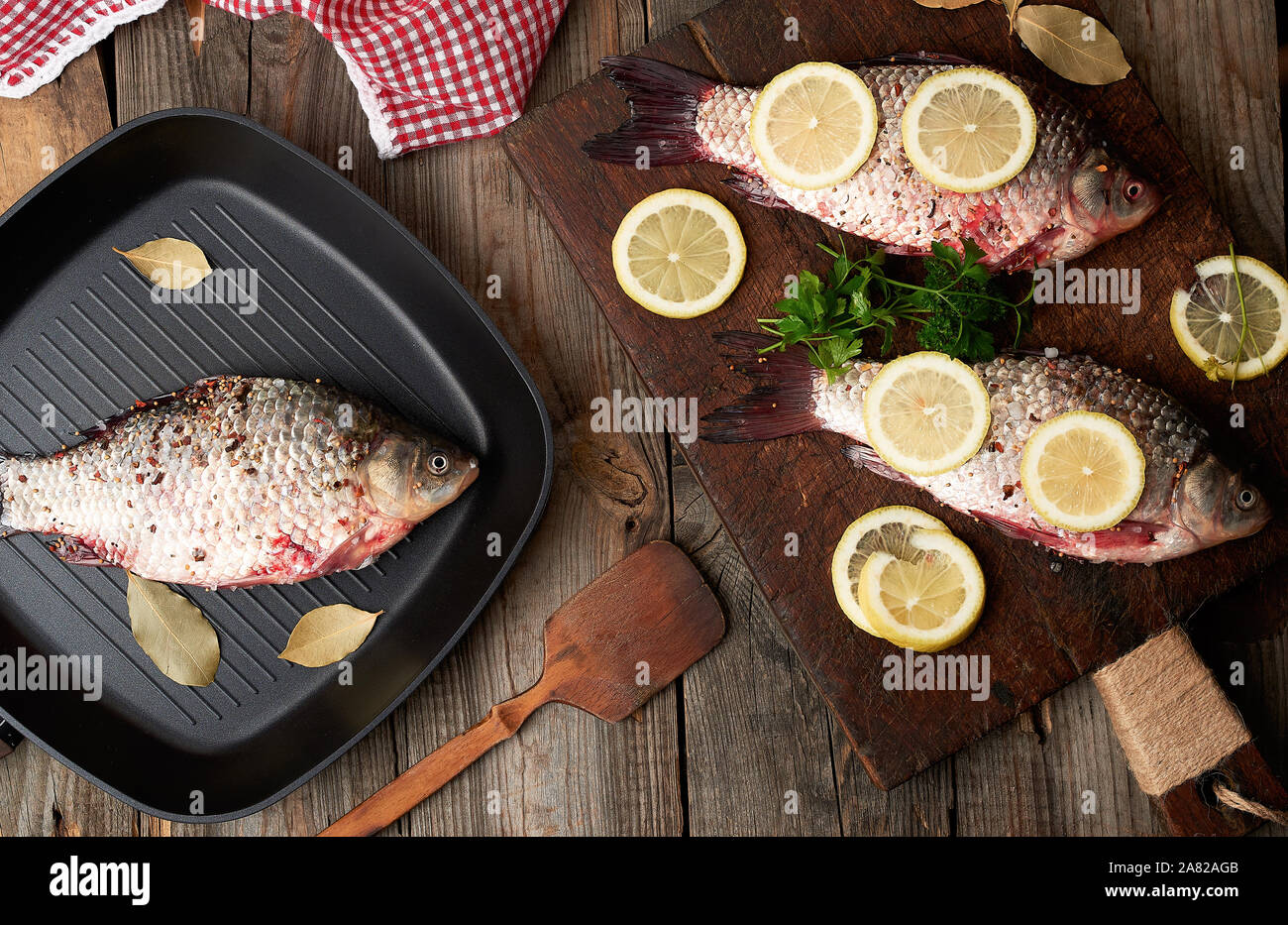 fresh fish in crucian scales on a brown old wooden cutting board, food ...