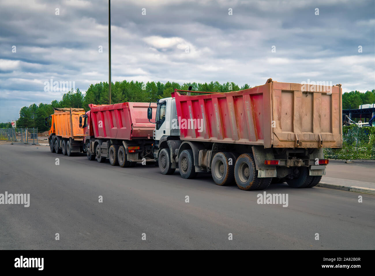 Lorries dump trucks at a construction site are waiting in line for ...