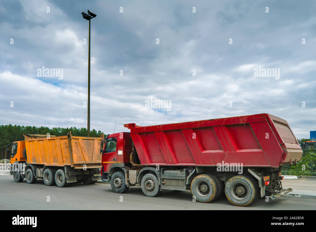 Lorries dump trucks at a construction site are waiting in line for ...