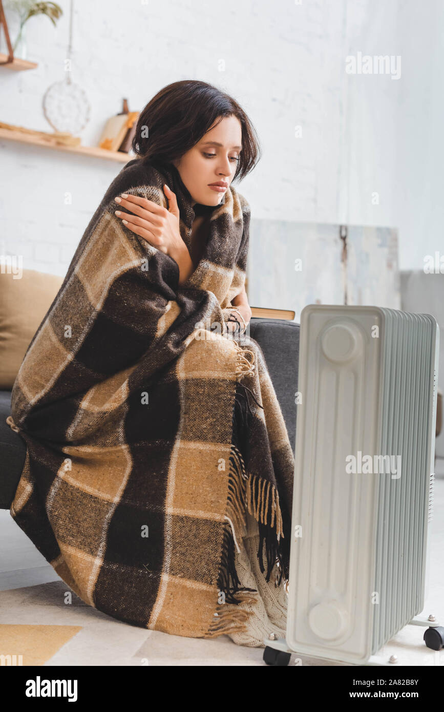 beautiful cold girl with blanket in room with heater Stock Photo - Alamy