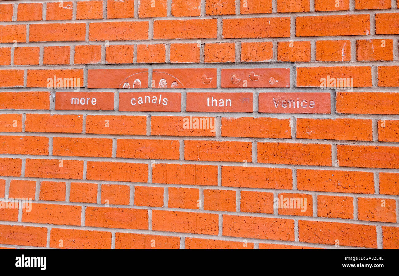 A red brick wall with lettering on it saying 'more canals than Venice ...