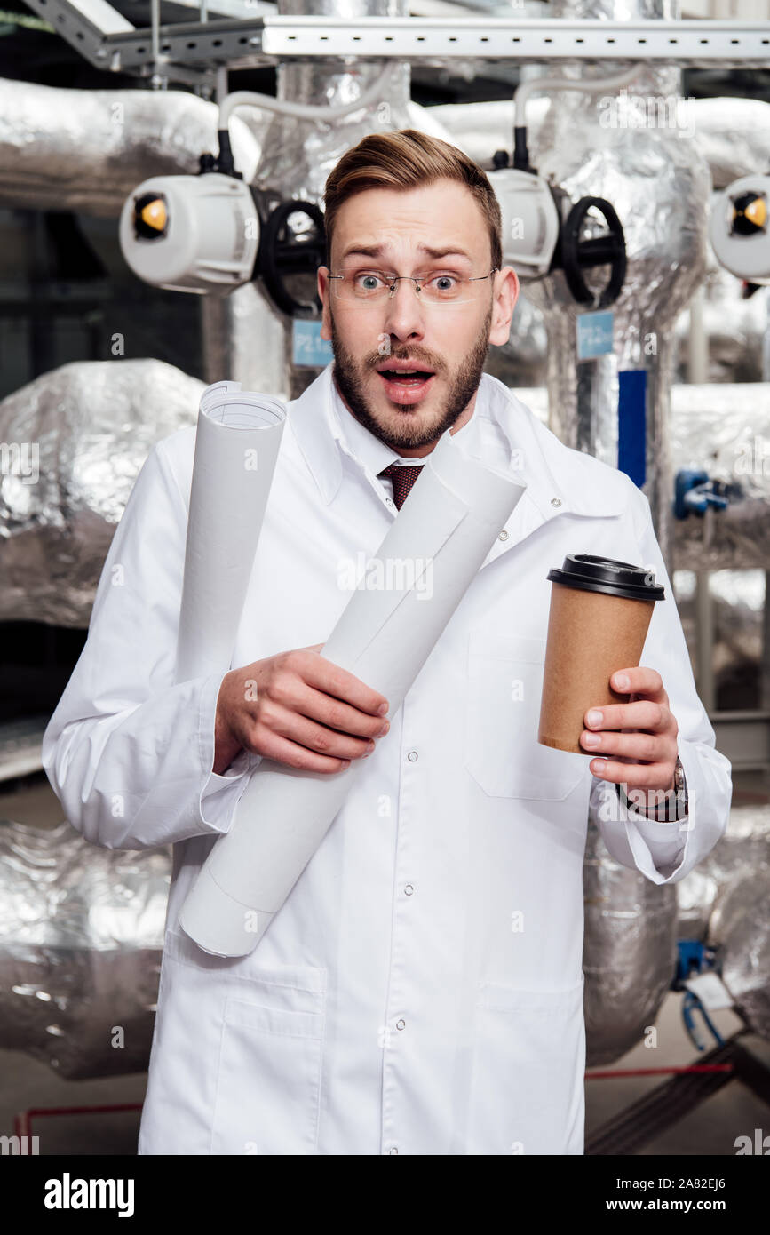 scared engineer in white coat and glasses holding blueprints and paper ...