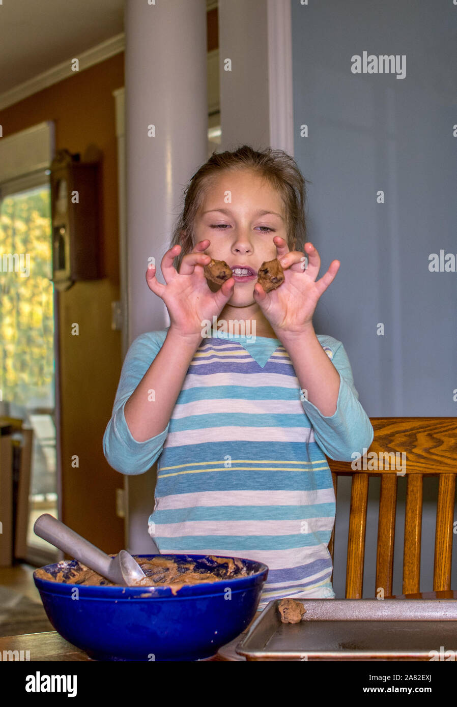 A little girl shows off the cookie dough balls she has formed for ...
