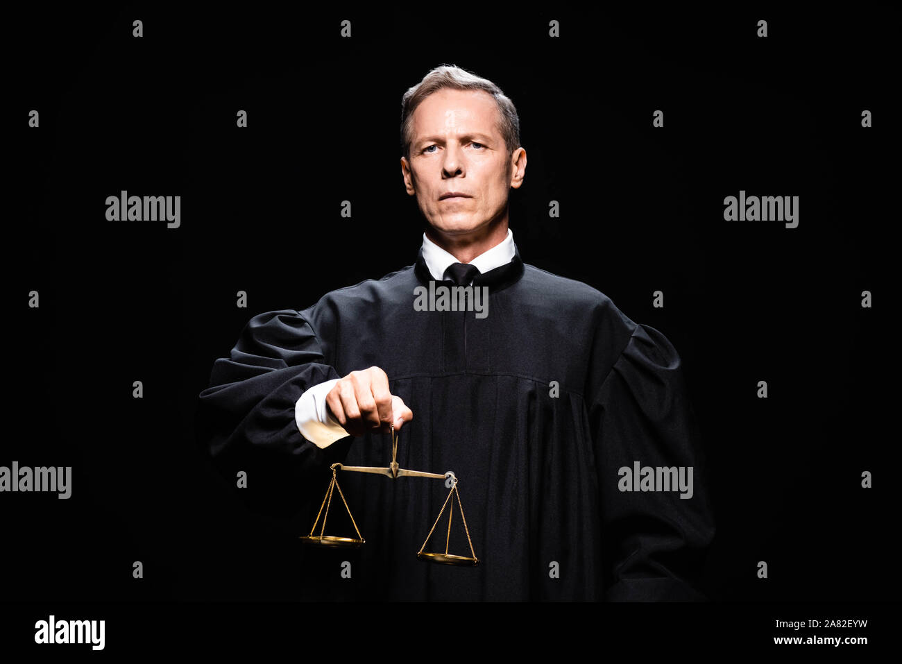 judge in judicial robe holding scales of justice isolated on black ...