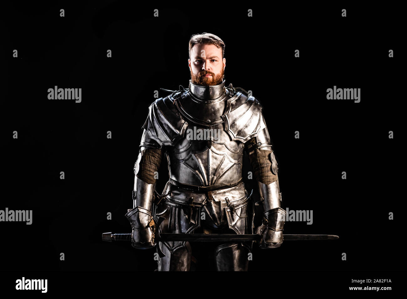 handsome knight in armor holding sword isolated on black Stock Photo ...