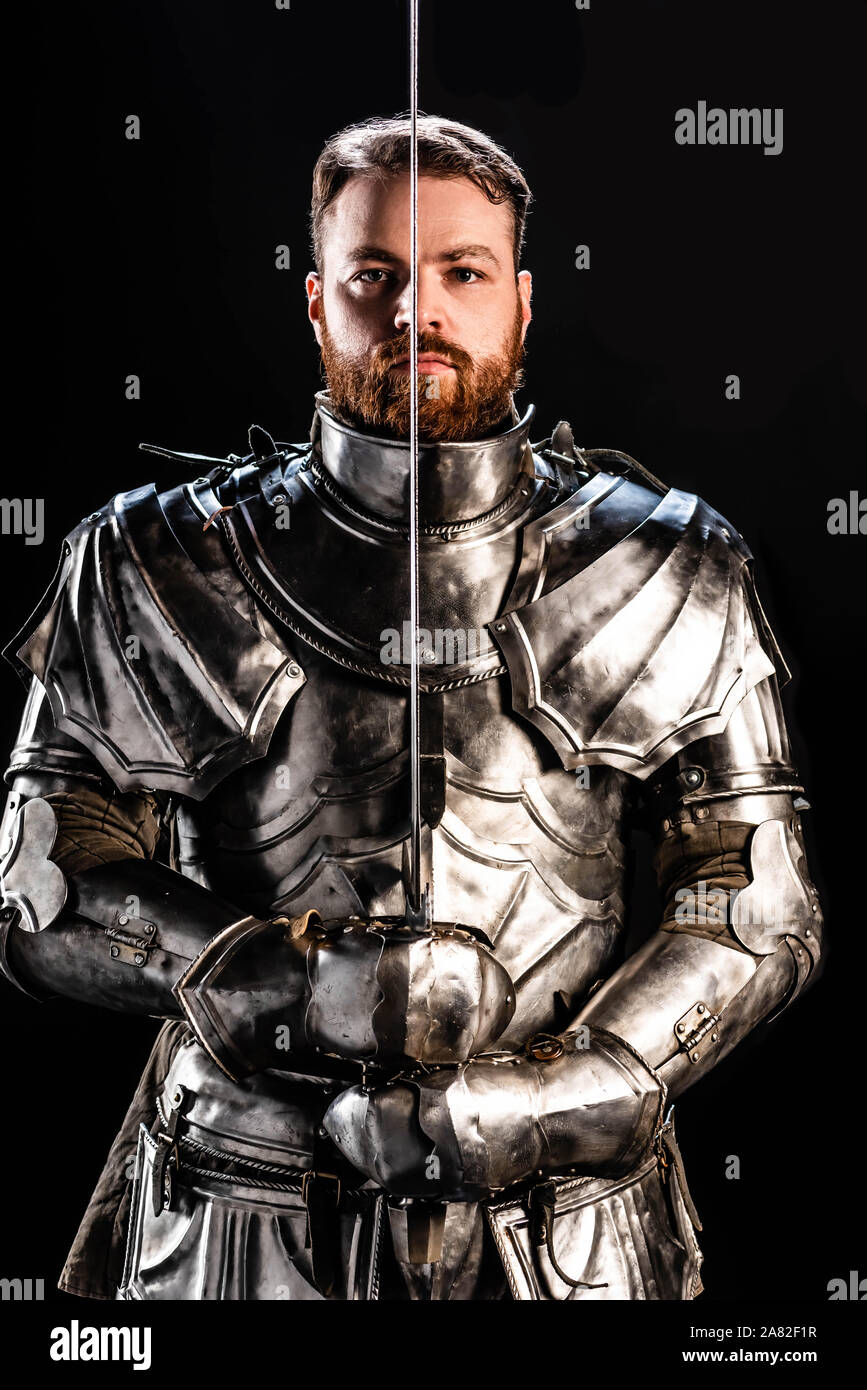 handsome knight in armor holding sword isolated on black Stock Photo ...