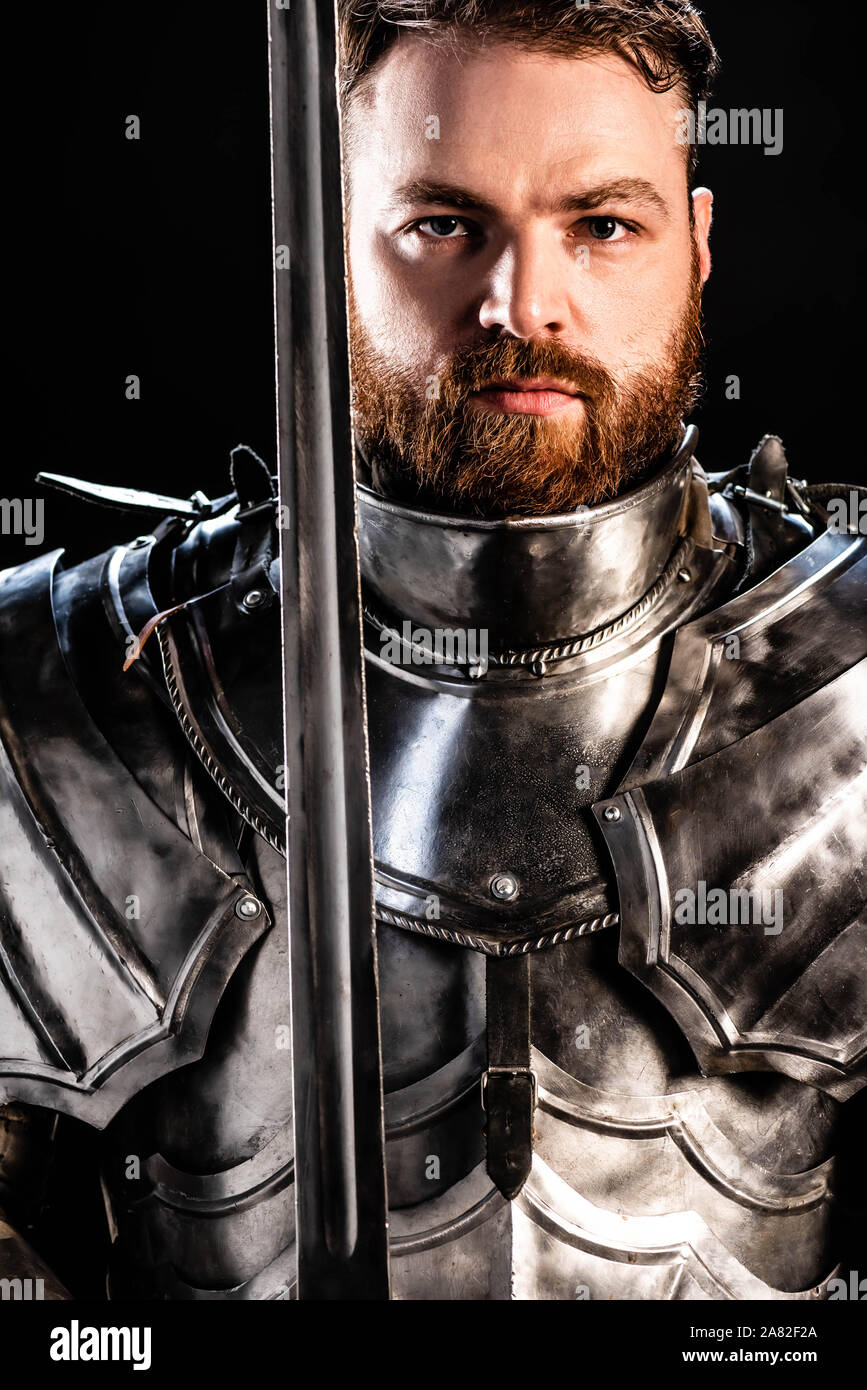 handsome knight in armor holding sword isolated on black Stock Photo ...