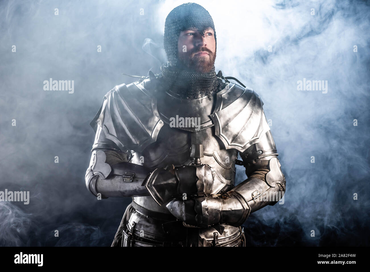 handsome knight in armor looking away on black background Stock Photo ...