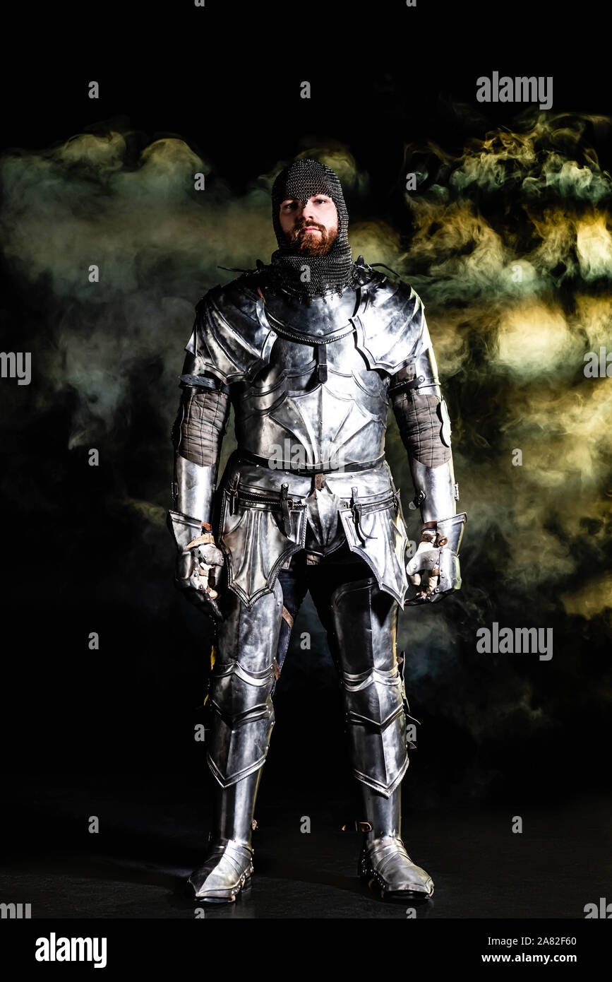 handsome knight in armor looking at camera on black background Stock ...