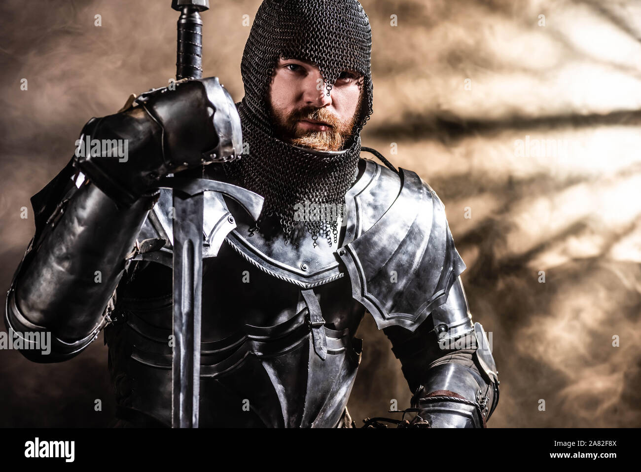 handsome knight in armor holding sword on black background Stock Photo ...