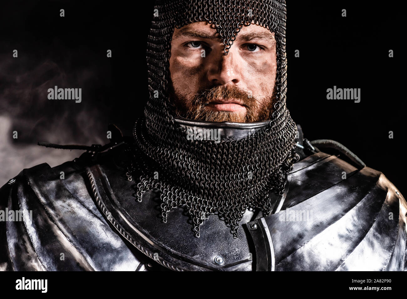 handsome knight in armor looking at camera on black background Stock ...