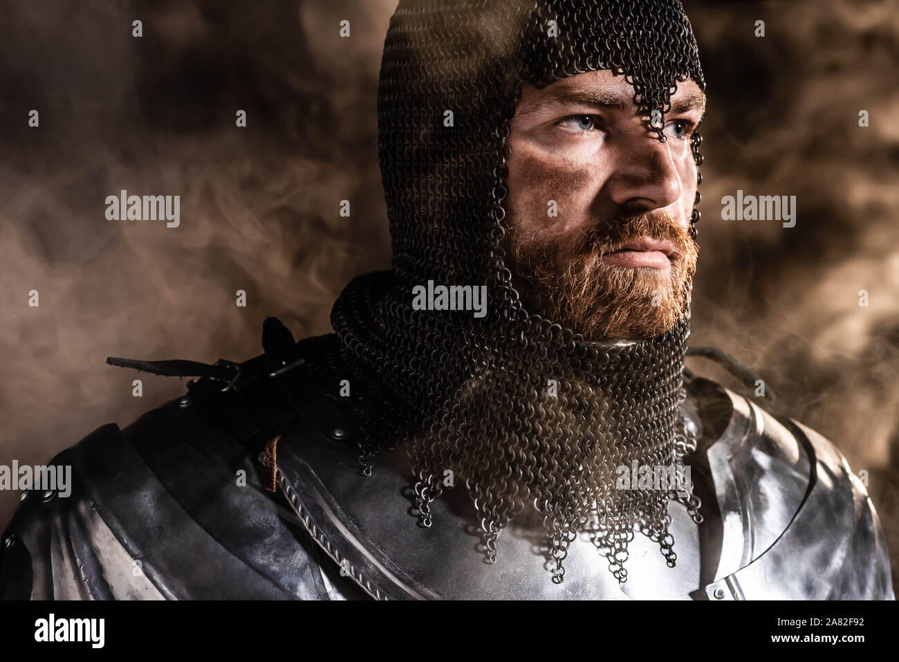 handsome knight in armor looking away on black background Stock Photo ...