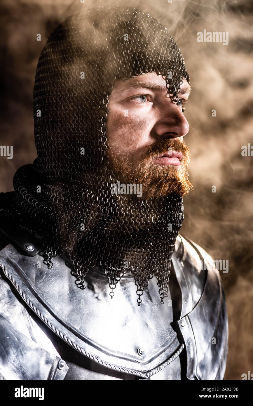 handsome knight in armor looking away on black background Stock Photo ...