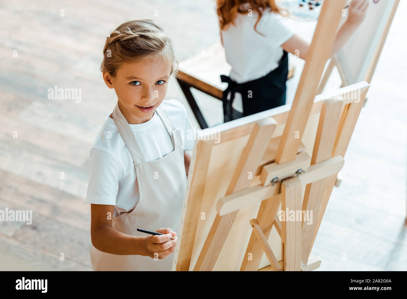 overhead view of cute kid looking at camera in art school Stock Photo ...
