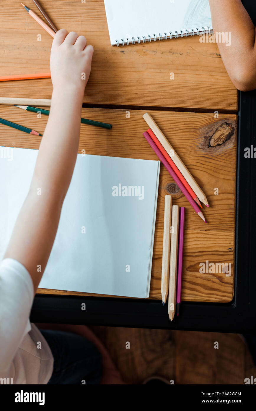 top view of kid taking color pencil near child Stock Photo - Alamy
