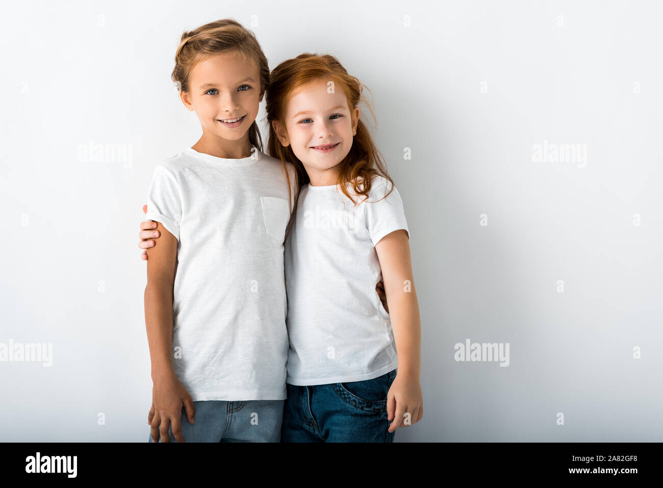 cheerful kids hugging while standing on white Stock Photo - Alamy