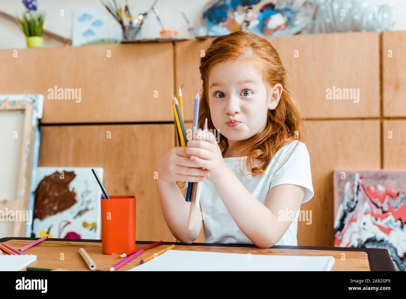 cute redhead kid holding color pencils in art school Stock Photo - Alamy