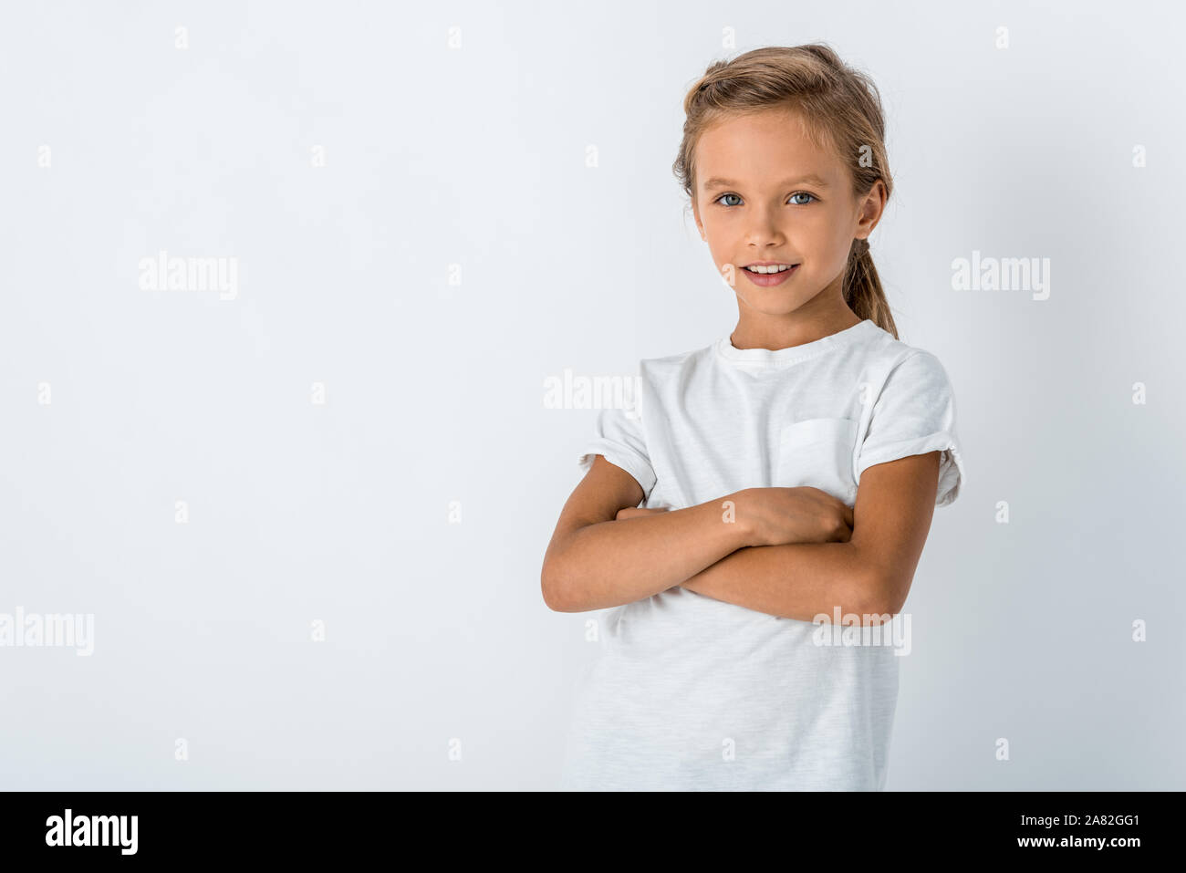 happy child standing with crossed arms on white Stock Photo - Alamy