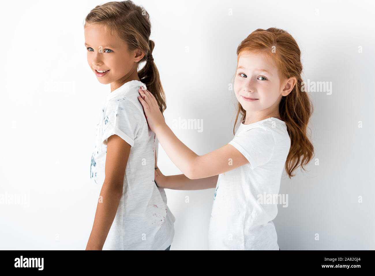 cute redhead kid touching child while standing on white Stock Photo - Alamy