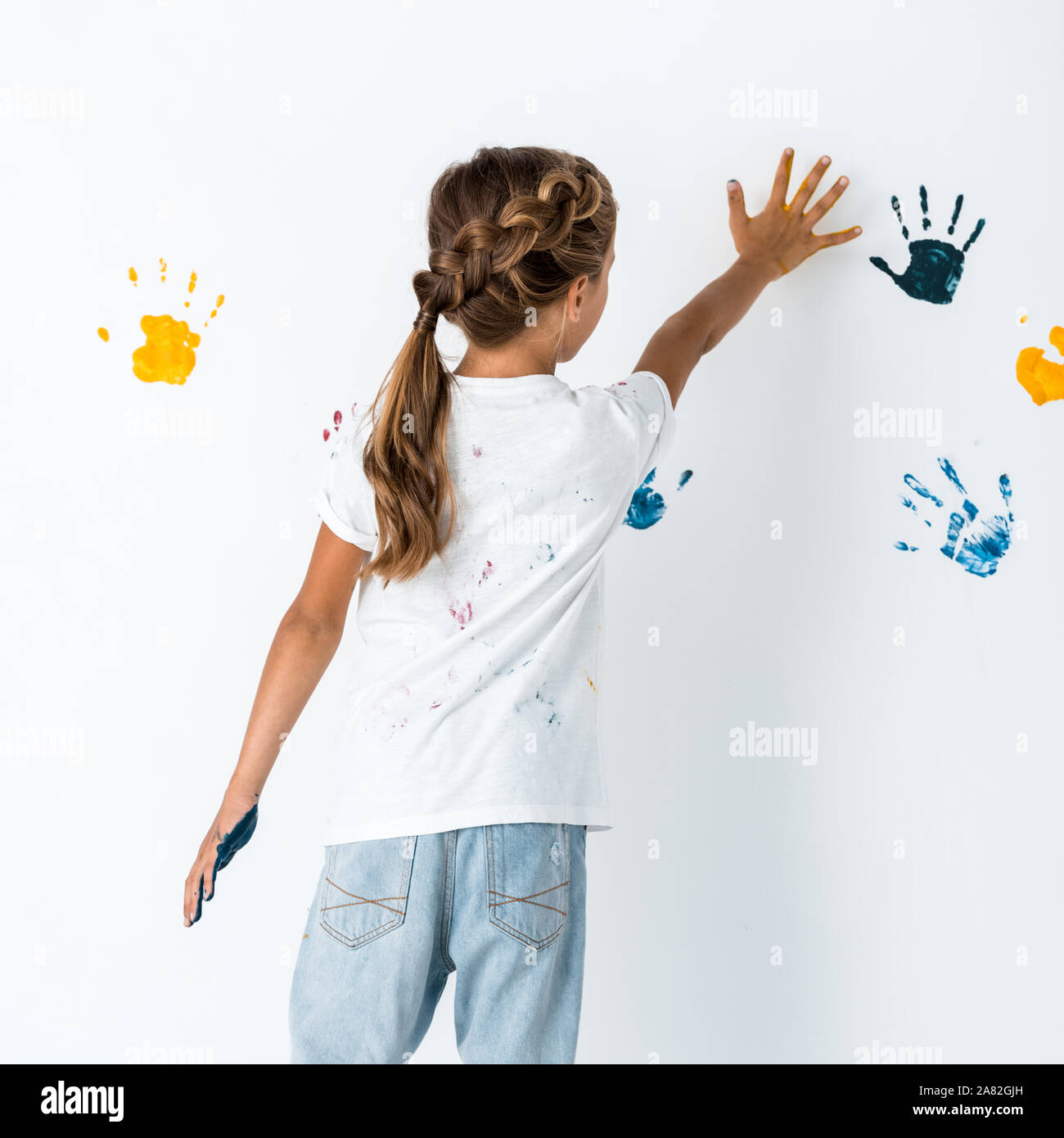 back view of kid putting hand near hand prints on white Stock Photo - Alamy