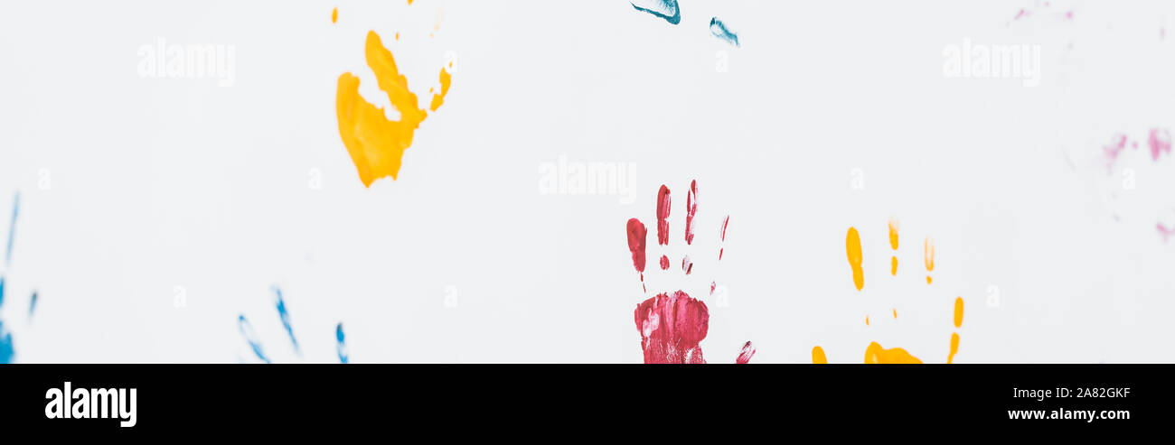 panoramic shot of yellow, blue and red hand prints on white Stock Photo ...