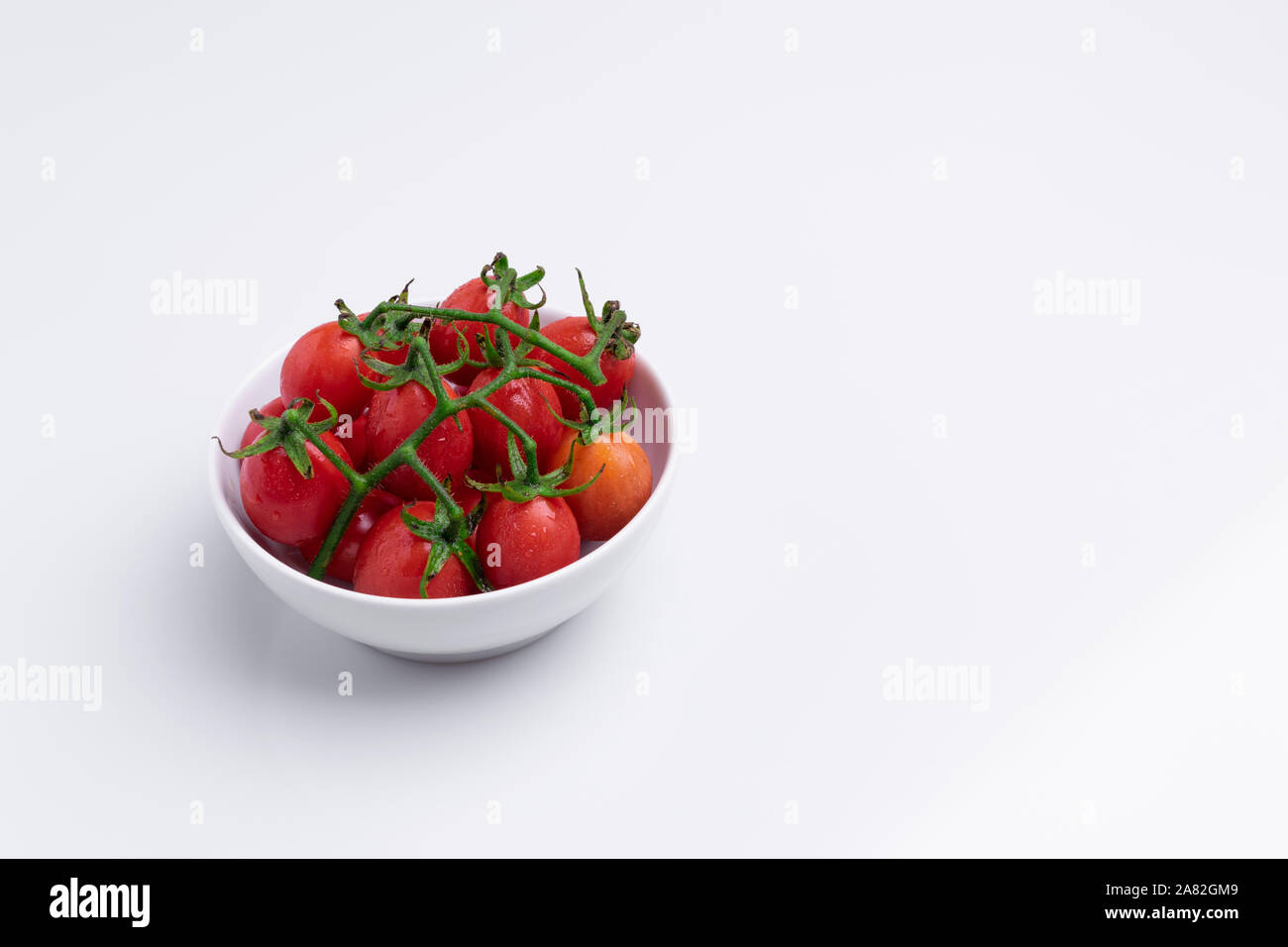 Grape or cherry tomato branch. Pile of red grape tomatoes isolated on ...