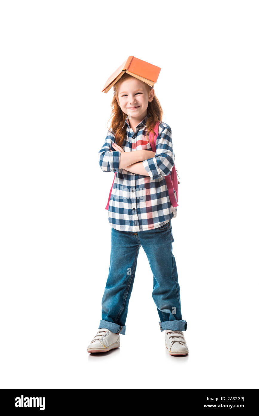 cheerful redhead kid with orange book on head standing with crossed ...