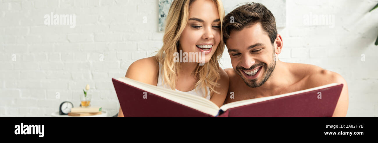 excited couple reading book together in bed in the morning Stock Photo ...
