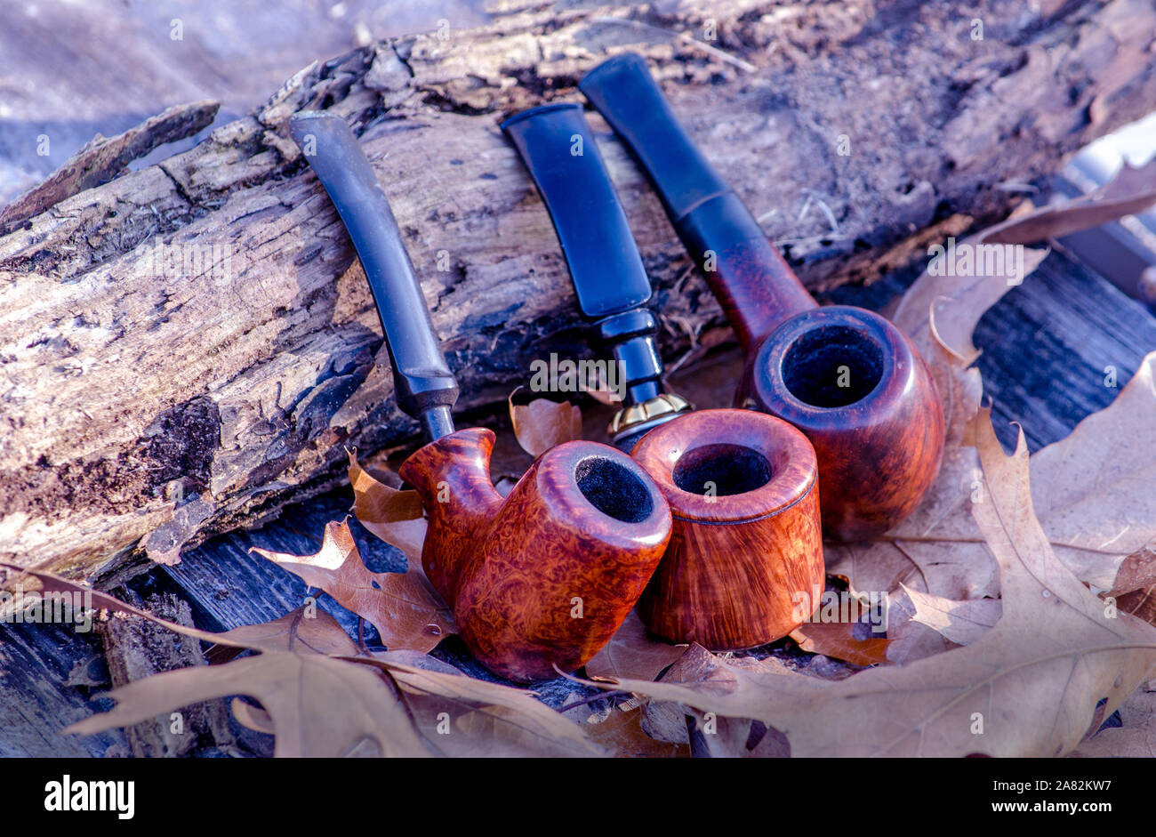 collection of briar pipes on a rustic backdrop Stock Photo - Alamy