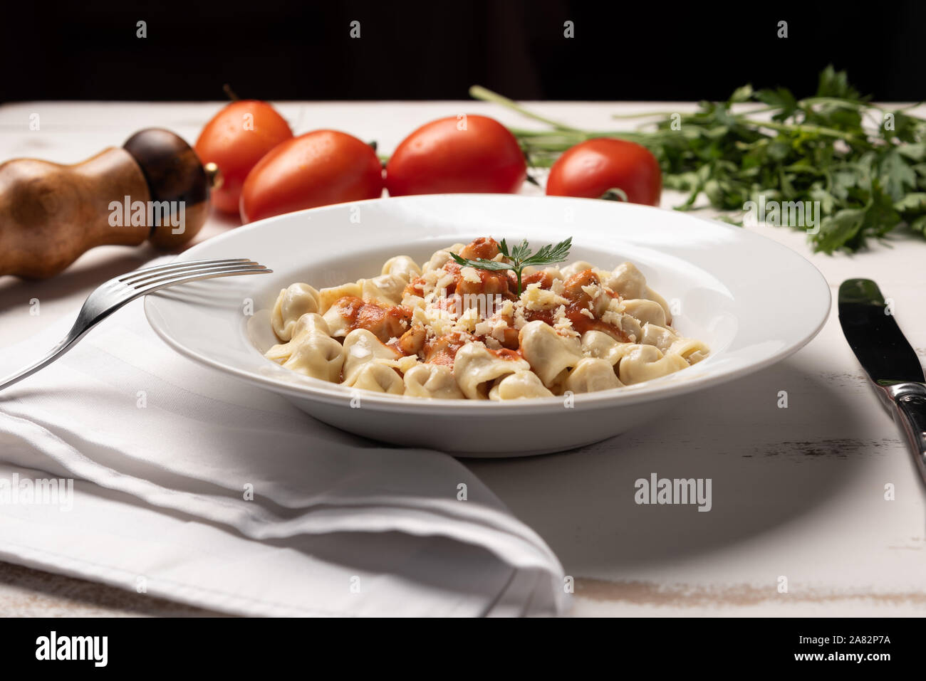Italian tortellini (capeletti, agnolini) with tomato sauce in a white ...