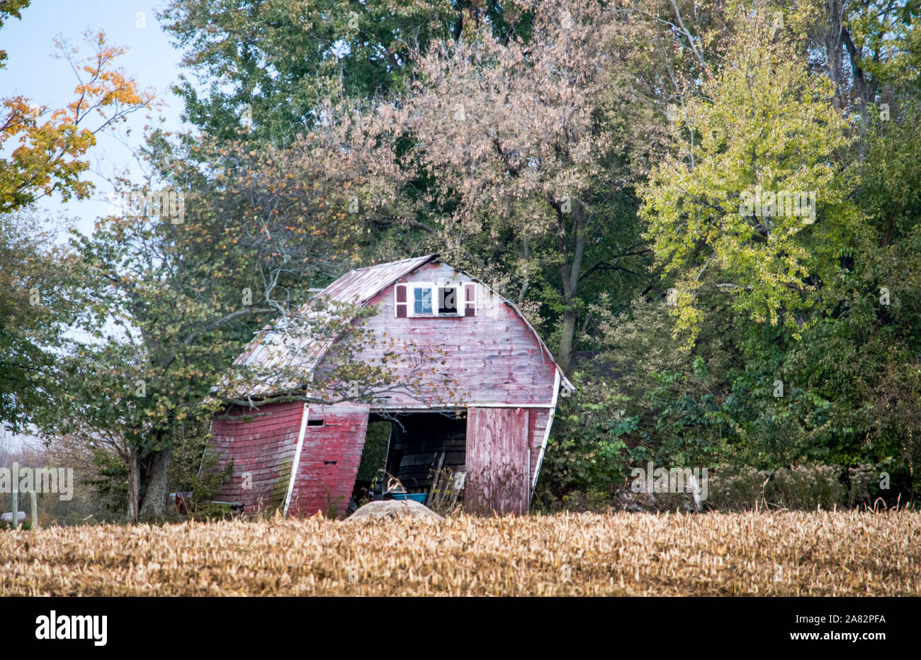 this old red barn looks like a small wind might blow it over at any ...