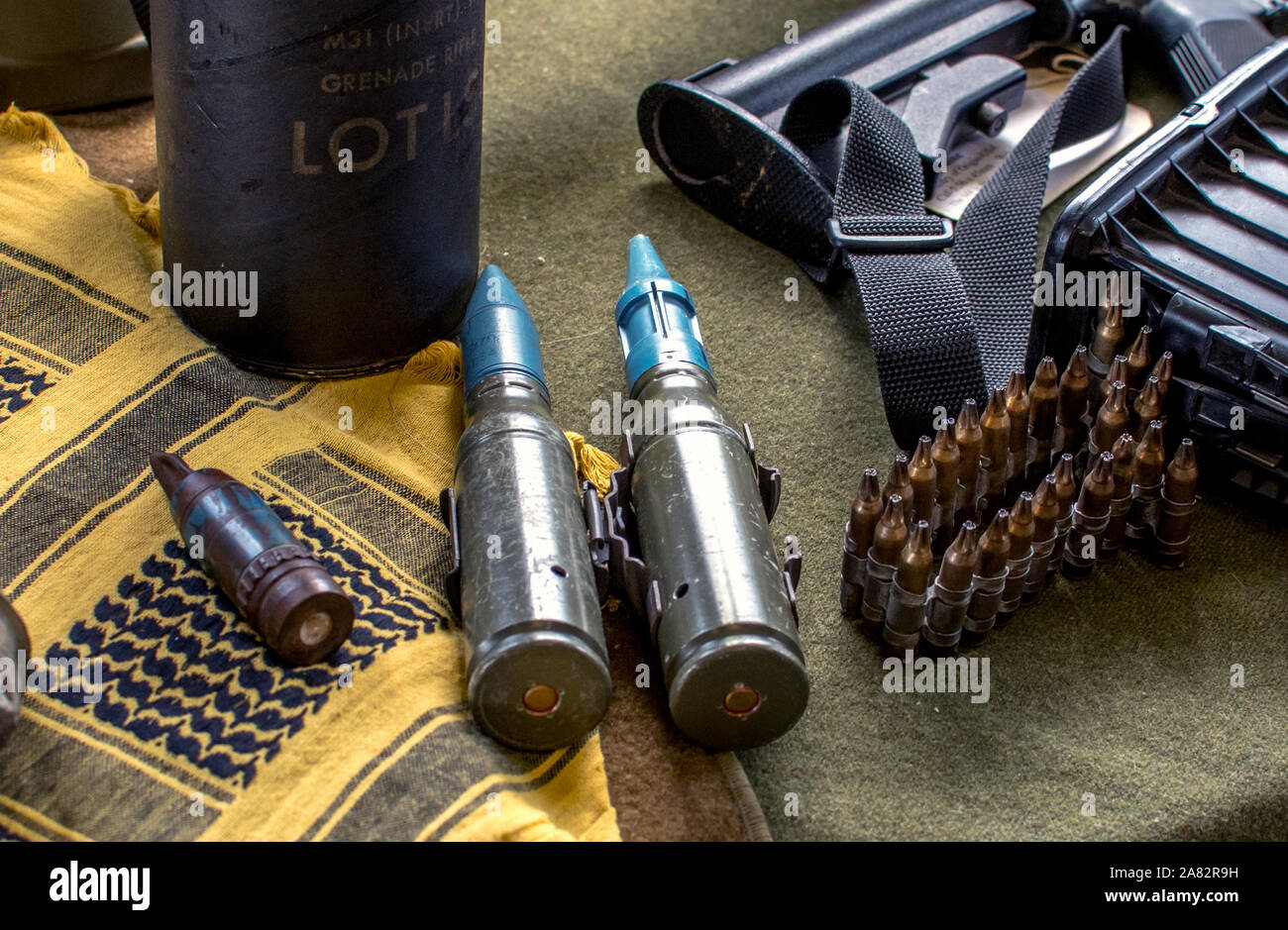 a display of weapons, bullets, grenades and grenade canister, are ...
