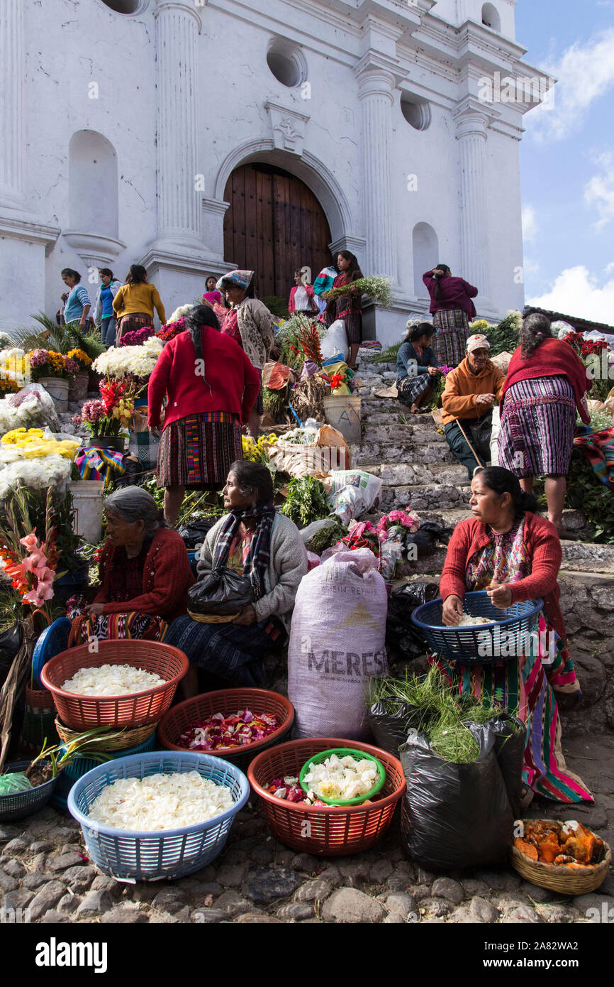 Quiche Mayan women in traditional dress selling flowers on the steps of ...