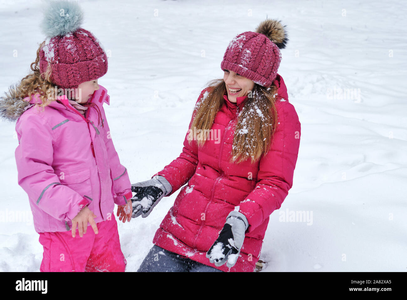 Fashionable stylish family having fun playing in snow. Weekends ...