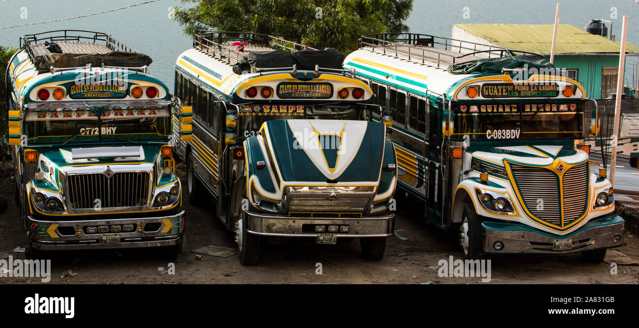 Three buses, known in Guatemala as chicken buses, await their next ...
