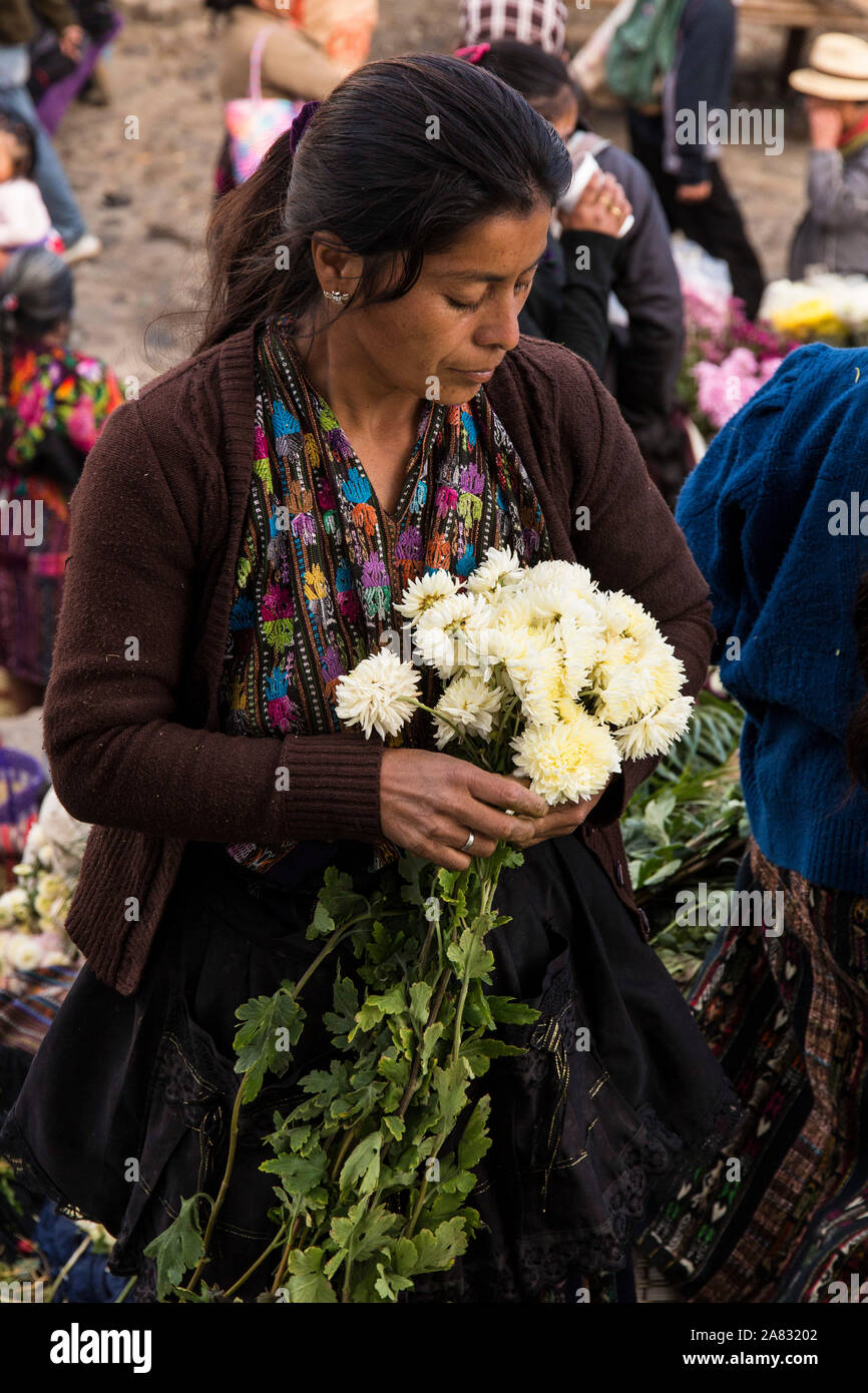 Quiche Mayan woman in traditional dress selling flowers on the steps of ...