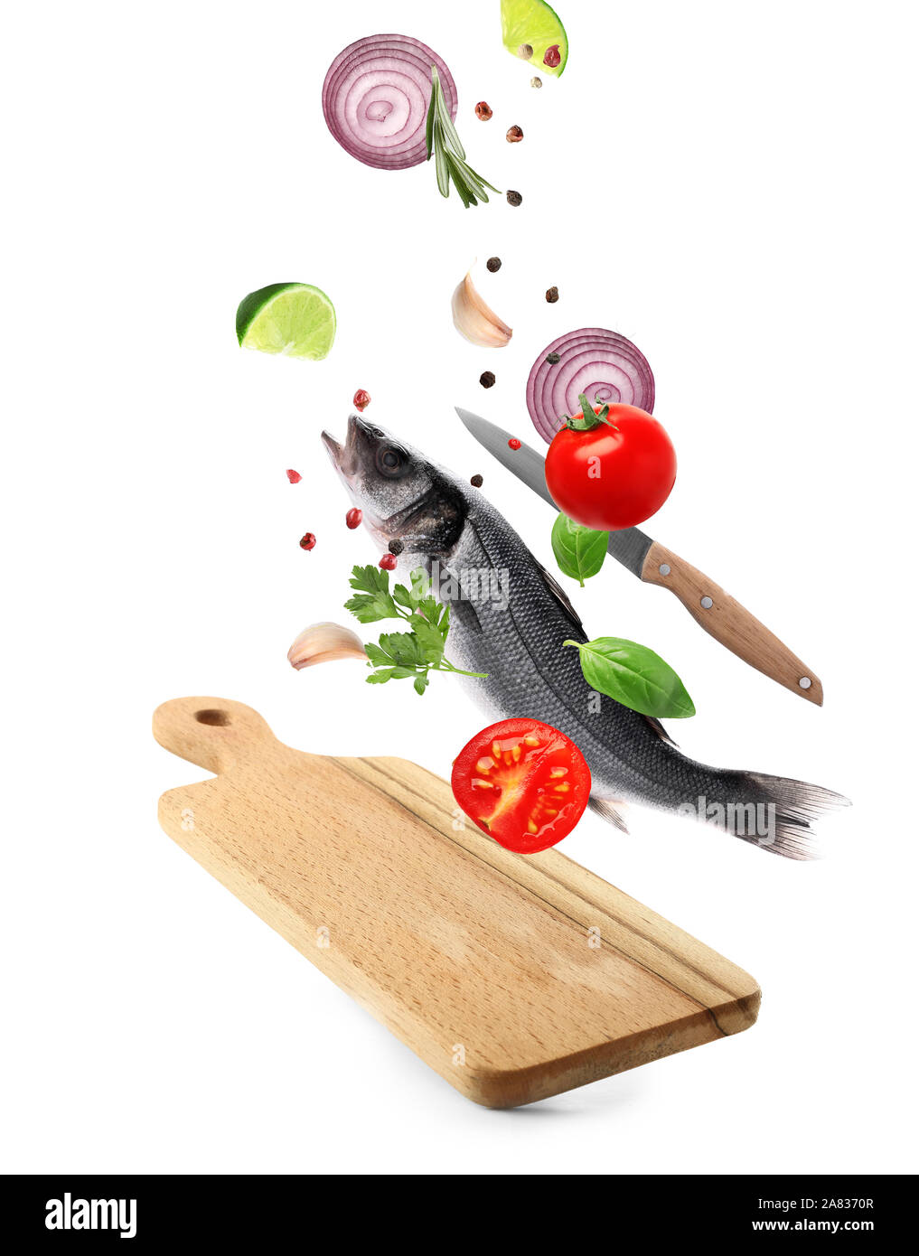 Wooden board and falling fish with ingredients on white background ...