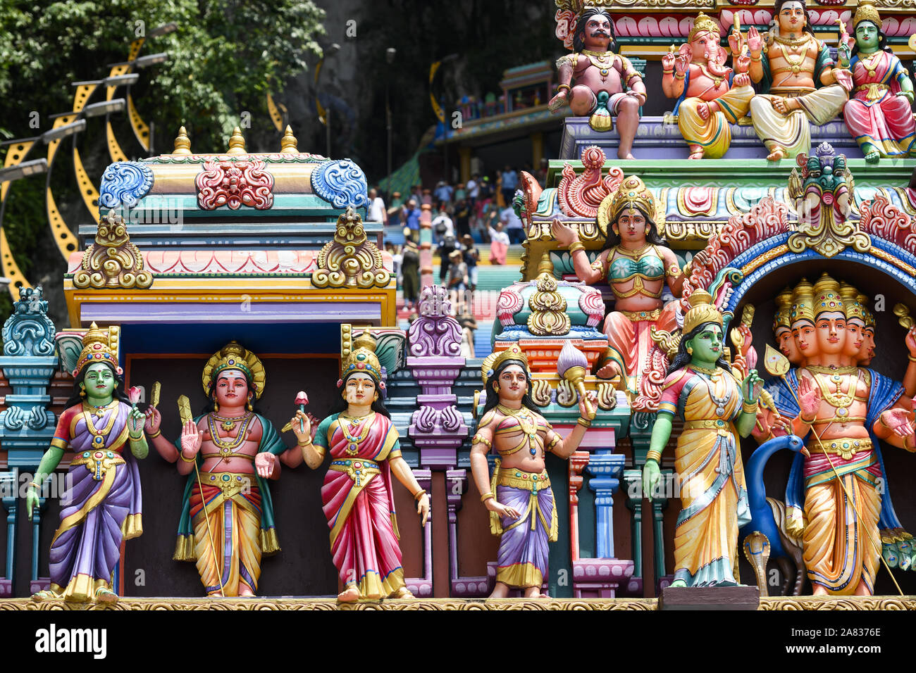 (Selective focus) Representation of Hindu gods and tourists climbing a ...