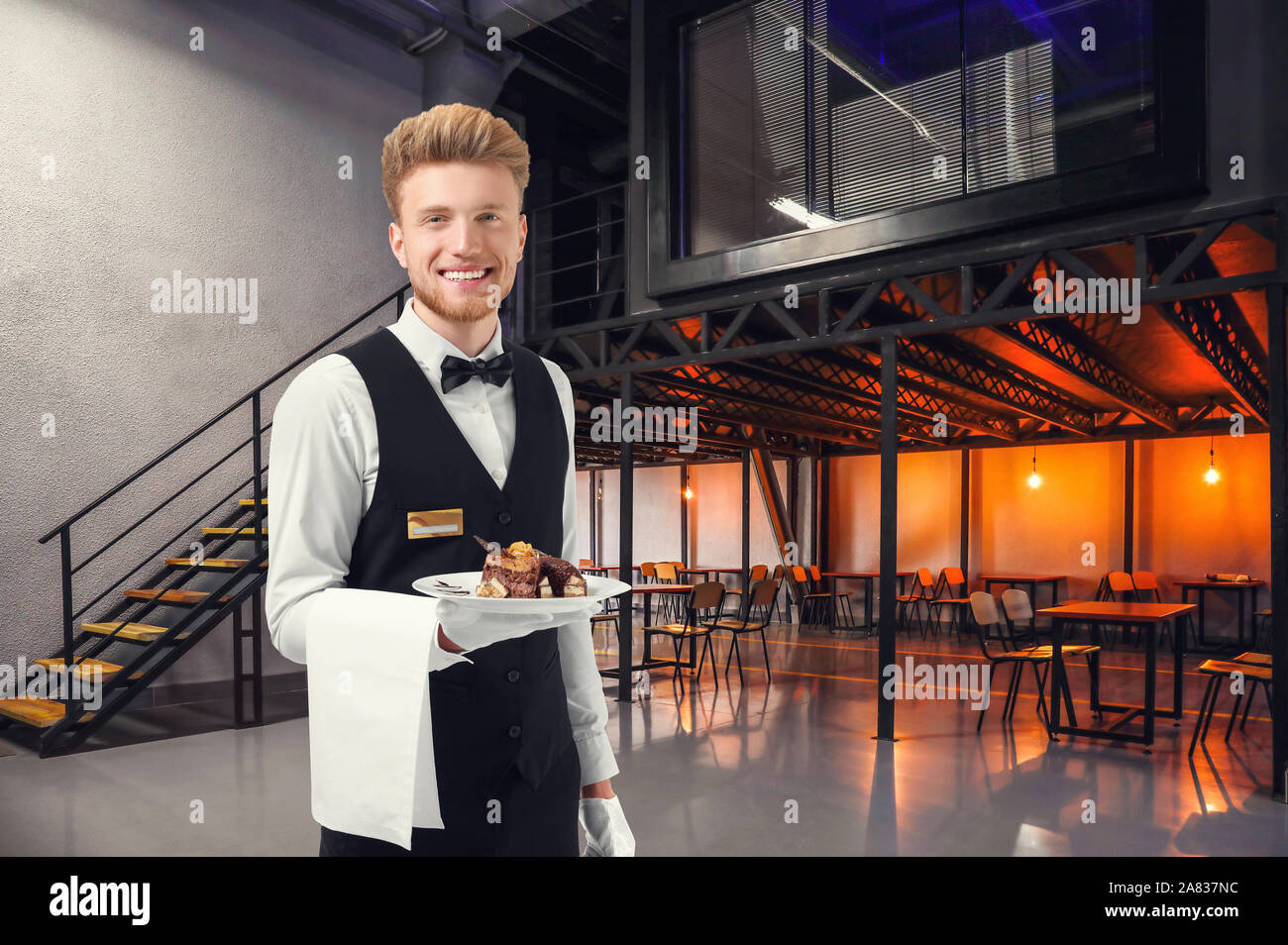 Handsome waiter with dessert in modern cafe Stock Photo - Alamy