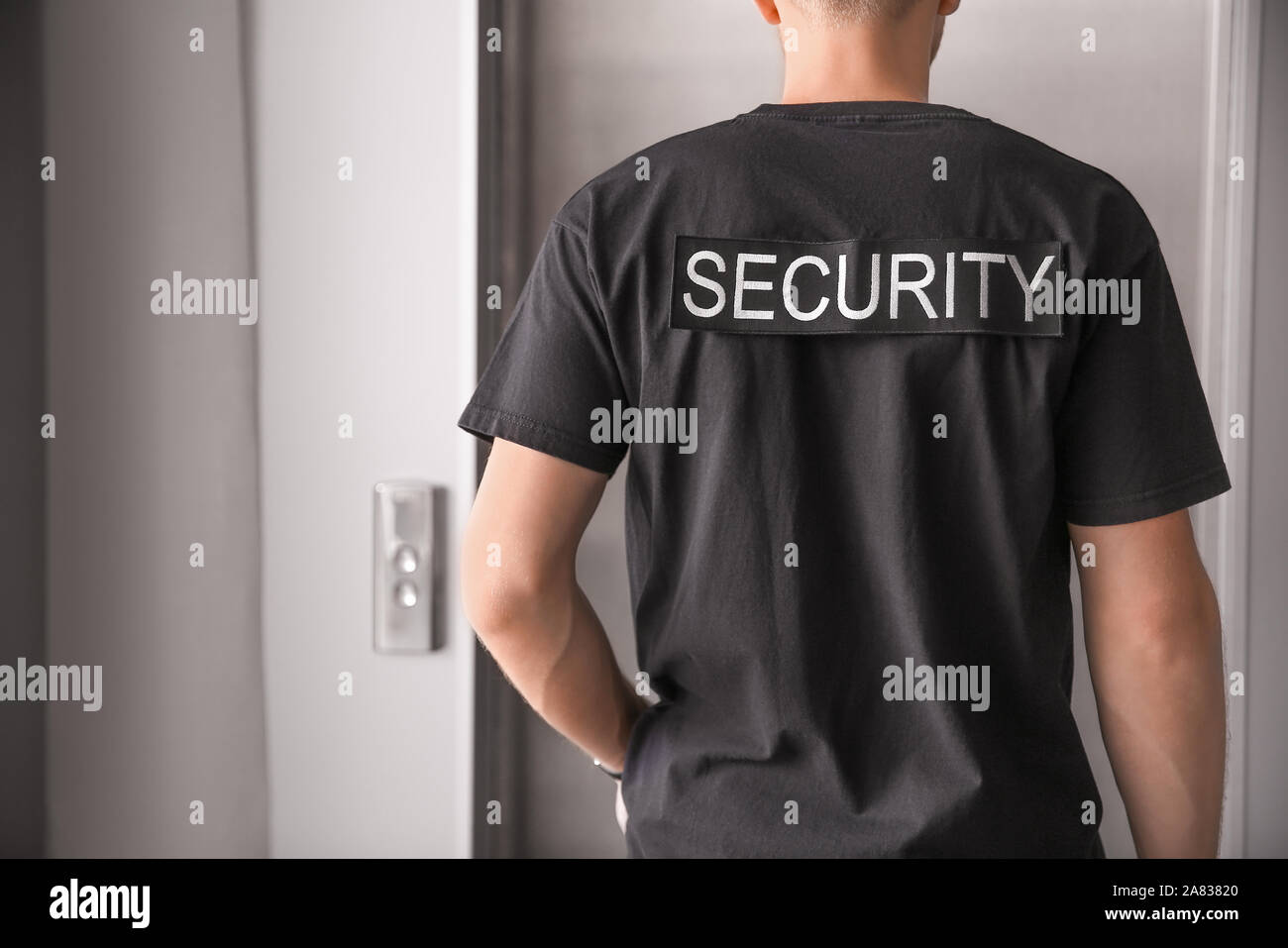 Male security guard near elevator Stock Photo - Alamy
