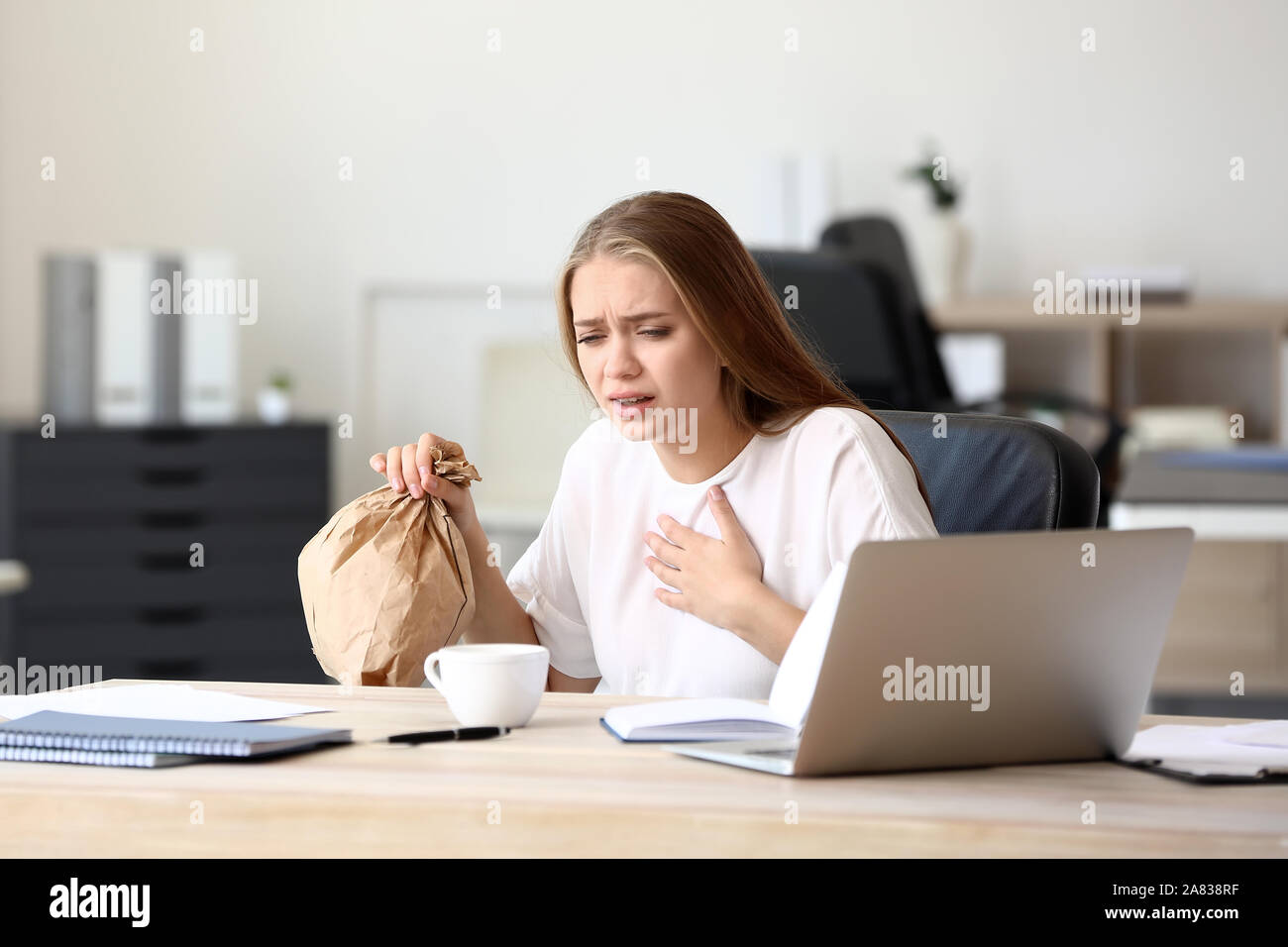 Woman having panic attack at workplace Stock Photo - Alamy