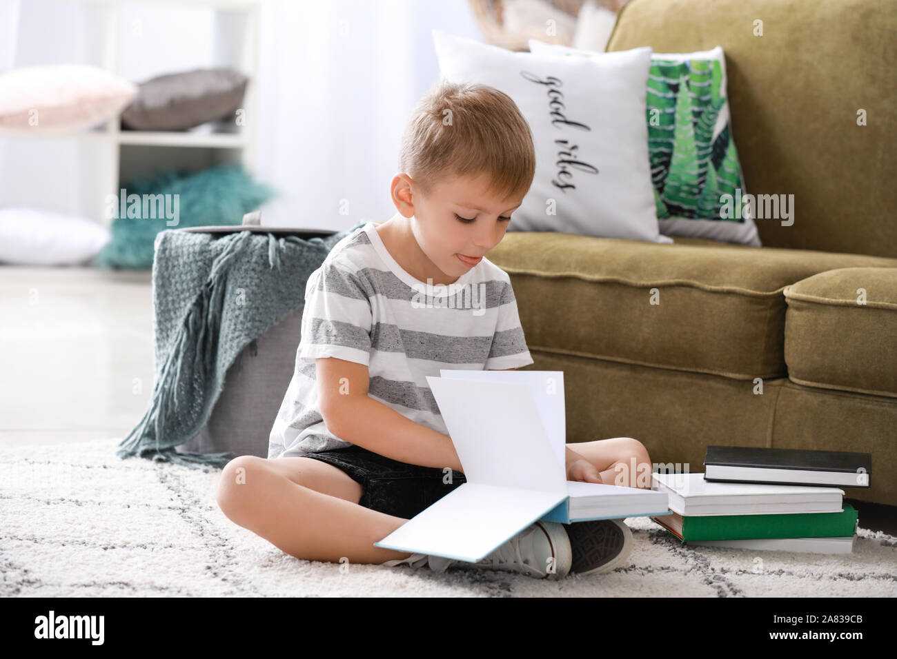 Cute little boy reading book at home Stock Photo - Alamy
