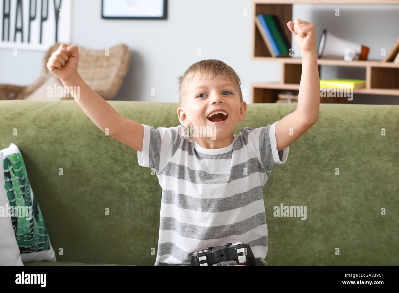 Happy little boy playing video games at home Stock Photo - Alamy
