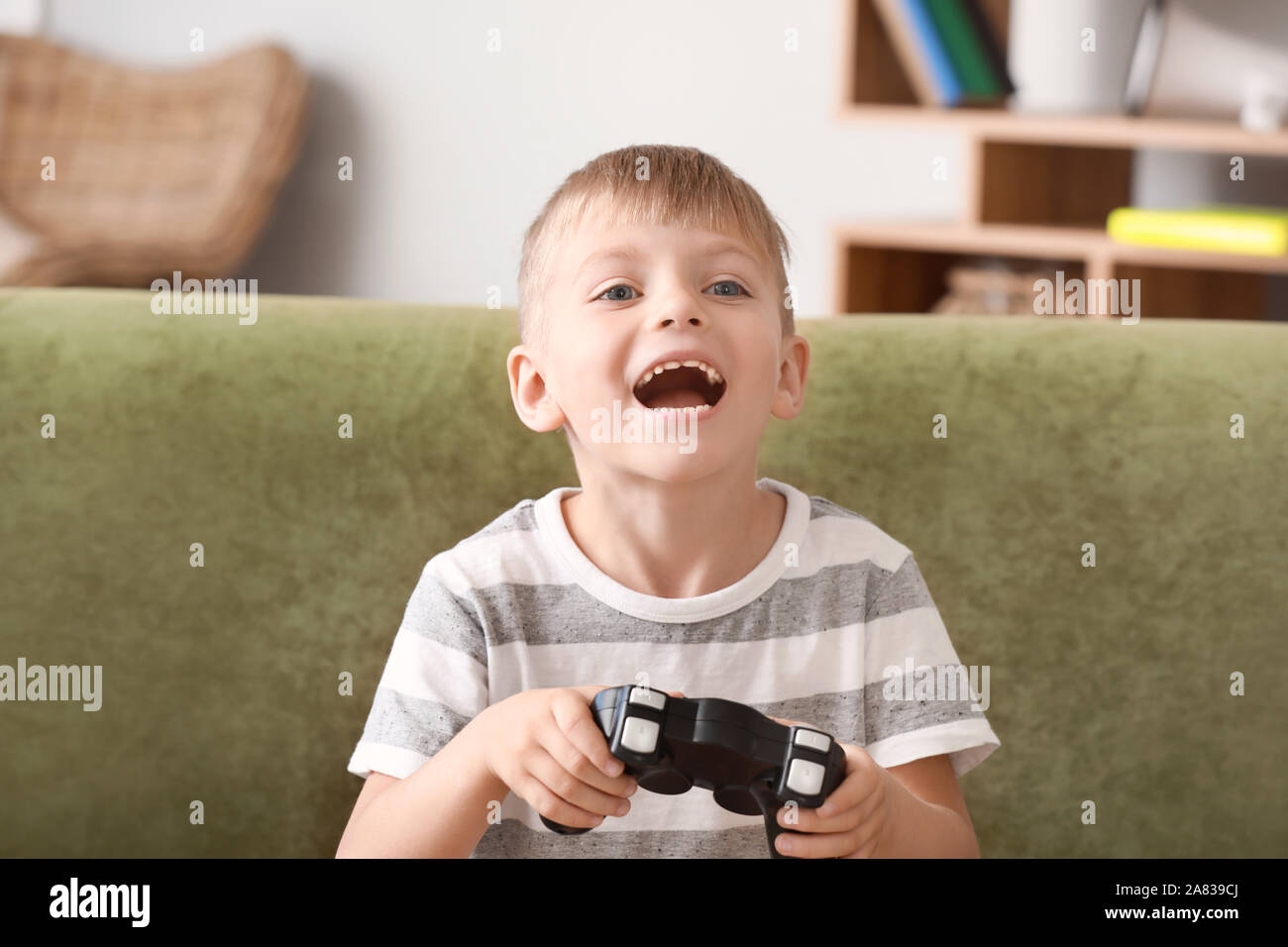 Emotional little boy playing video games at home Stock Photo - Alamy