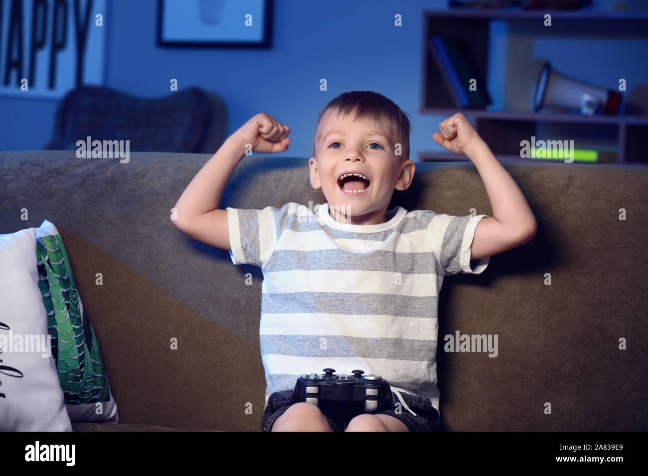 Happy little boy playing video games at home in evening Stock Photo - Alamy