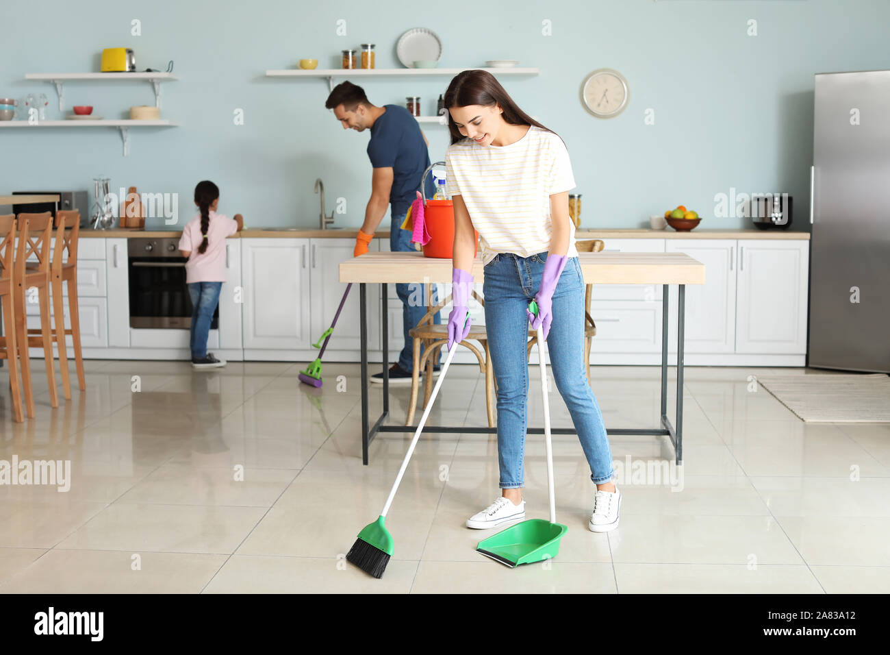 Happy family cleaning kitchen together Stock Photo - Alamy