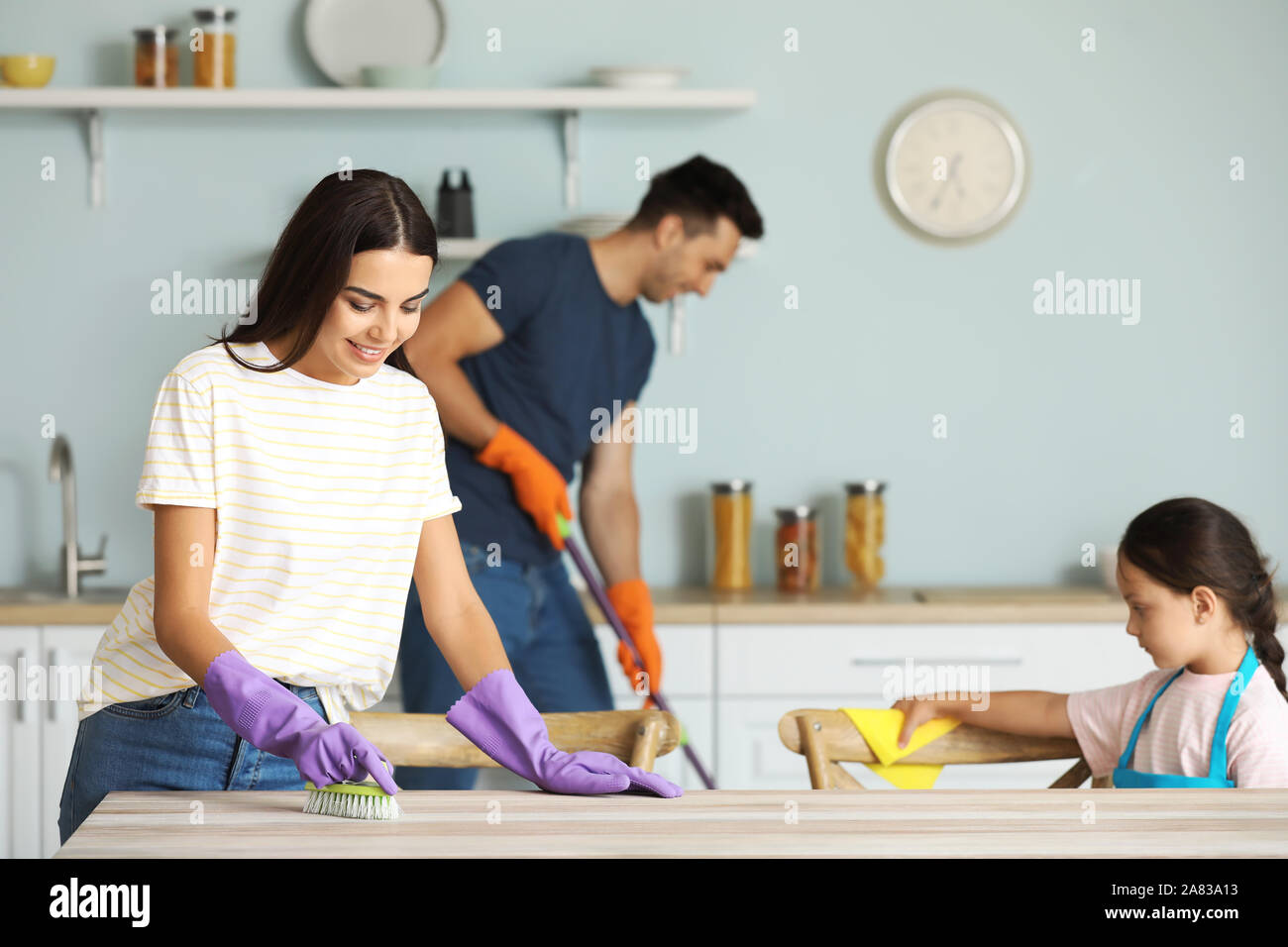 Happy family cleaning kitchen together Stock Photo - Alamy