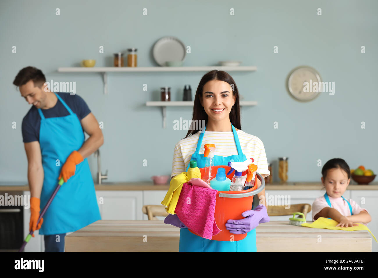 Happy family cleaning kitchen together Stock Photo - Alamy