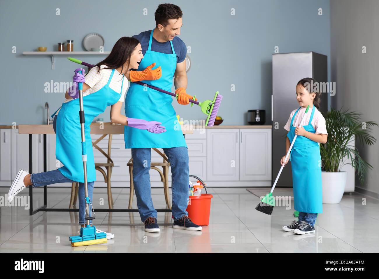 Happy family cleaning kitchen together Stock Photo - Alamy
