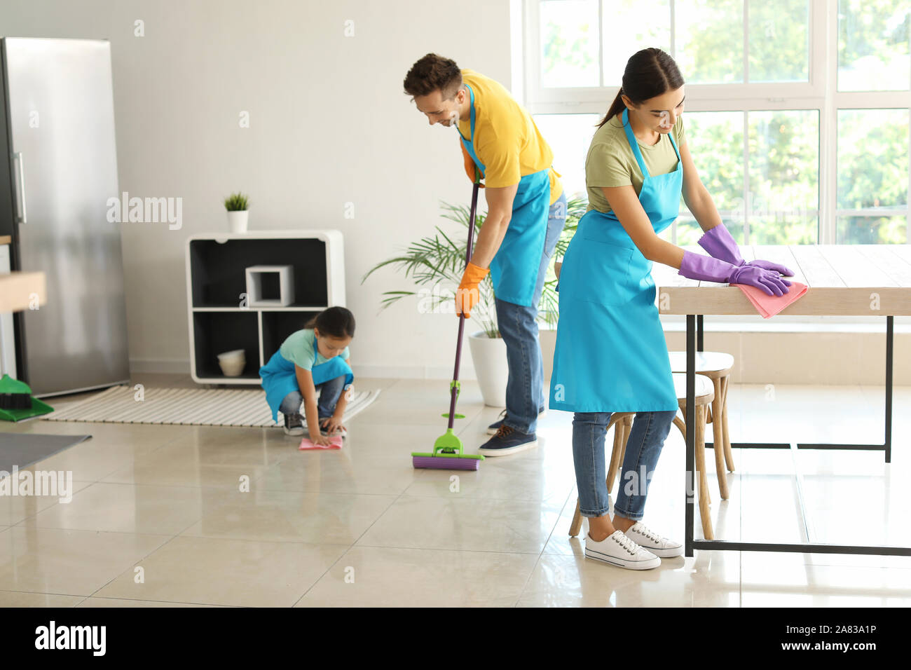 Happy family cleaning kitchen together Stock Photo - Alamy